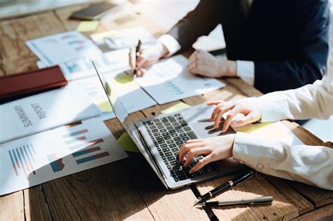 투자 위험을 줄이기위한 계획 파트너와 함께 일하는 사업가 그룹의 이미지는 회의에서 수익성 있고 표적화 된 고객 요구를 분석하기위한 마케팅 전략을 조정하고 있습니다 2명에