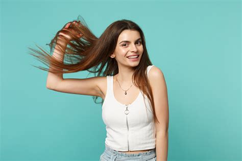 스튜디오에서 파란색 청록색 벽 배경에 고립 된 머리를 들고 가벼운 캐주얼 의류에 웃는 젊은 여자의 초상화 사람들은 진심으로 감정 라이프 스타일 개념입니다 복사 공간을 모의