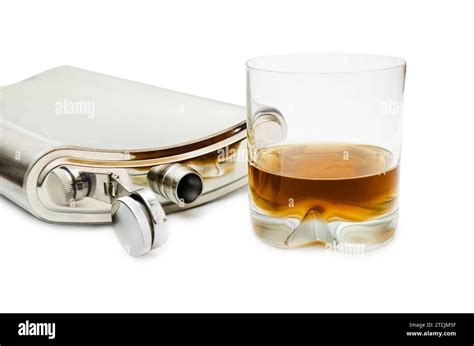Close Up Of A Silver Metal Flask And A Glass With Liquid Alcoholic Drink On A White Background