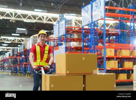 Shipping Boxes Asian Man Warehouse Worker Unloading Pallet Shipment Goods Into A Truck