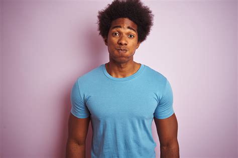 아프리카계 미국인 남자 와 아프리카 계 미국인 남자 Afro 머리 를 입고 푸른 티셔츠 위에 서 고립 된 분홍색 배경 퍼핑 뺨 재미 있는 얼굴 공기 미친 표정으로 입이 팽창