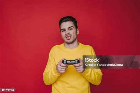 빨간 배경에 조이스틱을 들고 불쾌 한 갈색 머리 남자의 절반 길이 게이머에 대한 스톡 사진 및 기타 이미지 게이머 인물 사진 남자 Istock