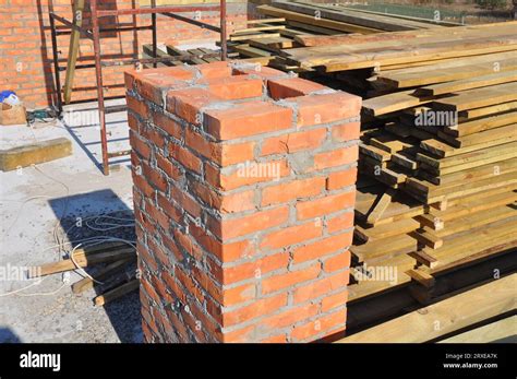 Building Chimney From Red Bricks In Unfinished House Construction Site