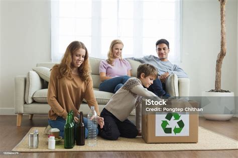 행복한 가족 부모는 딸과 아들이 재사용 또는 재활용을 위해 쓰레기 따로 집을 수거하고 종이 상자에 넣는 것을 지켜보았습니다 재생 가능 자원과 지속 가능한 개념 가족에 대한