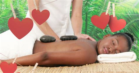 Masseuse Placing Hot Basalt Massage Stones On The Back Of An Attractive
