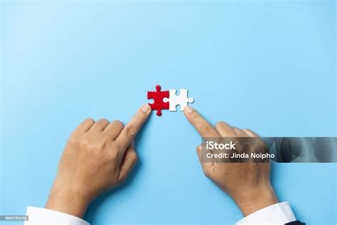 두 손이 파란색 배경에 몇 개의 퍼즐 조각을 연결하려고 합니다 팀웍 개념입니다 직소 퍼즐을 연결하는 손을 닫습니다 2명에 대한 스톡 사진 및 기타 이미지 Istock