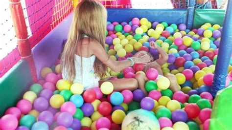 The Older Sister Plays With Her Younger Brother And Throws Small Balls