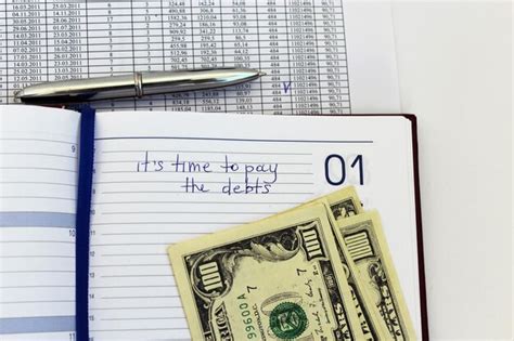 Premium Photo Writing Down In A Notebook About A Debt And American