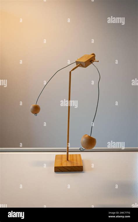 Wooden Figure On A Stick Where The Center Of Gravity Is Below The Pivot Point So That It Does