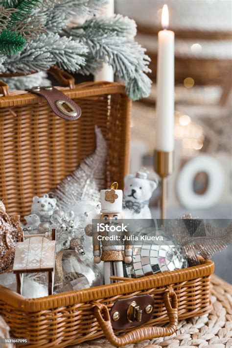 아늑한 겨울 컨셉 춥고 서리가 내린 날씨에 가정의 따뜻함 정물 크리스마스 장난감 고리 버들 바구니 양초 및 전나무 가지가 거실 홈 인테리어의 커피 테이블에 있습니다 0명에