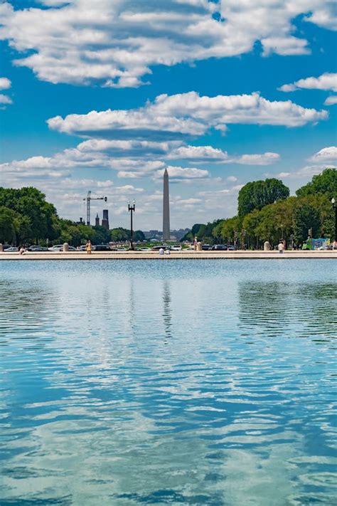 Bright Blue Skies Over The Washington Monument And Reflection In The Water Of The Reflecting