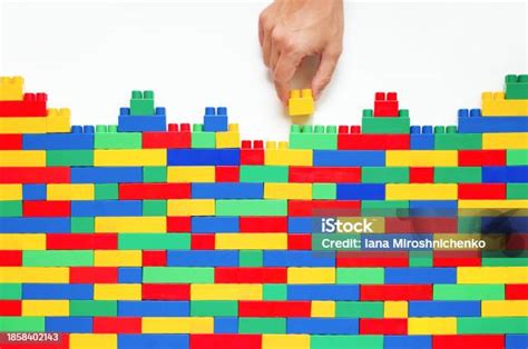 남자의 손 다채로운 플라스틱 벽돌 블록에서 벽에 최종 세부 사항을 배치합니다 사업효율화 사업개발 사업전략 수립 Theatrical Performance에 대한 스톡 사진 및