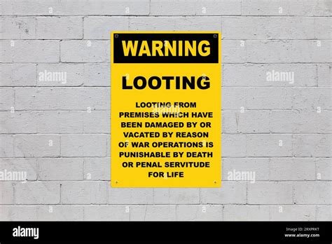 Yellow Warning Sign Screwed To A Brick Wall To Warn About The