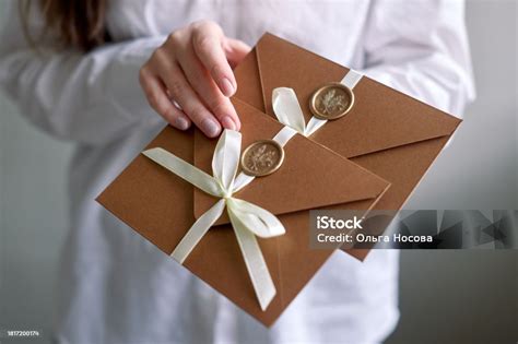 여자가 봉인된 봉투 두 개를 들고 있다 리본과 왁스 씰이 찍힌 초대장 봉투 상품권 청첩장 초대장에 대한 스톡 사진 및 기타 이미지 Istock