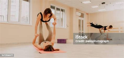 사전 자세로 요가를 연습하는 두 명의 스포티한 여성 스포츠웨어의 젊은 여성들은 함께 몸의 균형과 조화를 연습합니다 여성 피트니스