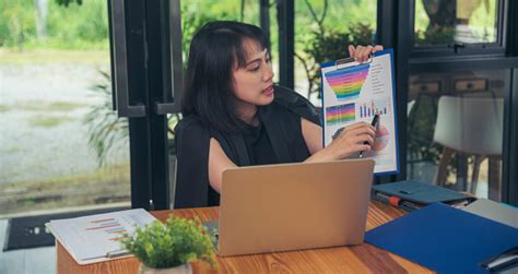 스마트 폰을 사용하는 비즈니스 여성 사무실 책상에 노트북 여성 프리랜서 독서 재무 그래프 차트 마케팅 데이터를 분석 계획 사무실