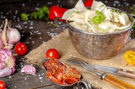 빈티지 소박한 그릇 접시 포크 나이프 숟가락 소금 향신료 신선한 허브 스탠드 와 거짓말 다른 각도 나무 절단 부엌 테이블에 어두운 빛에 빨간색과 흰색 생선 고기로 만든 만두