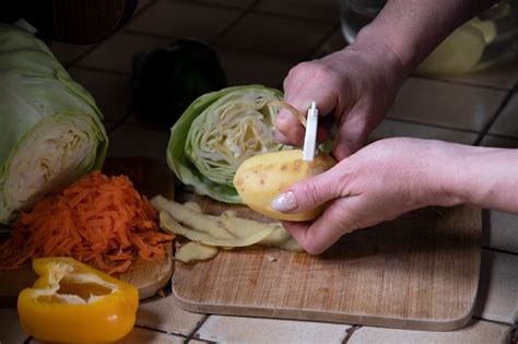 한 여성이 신선한 야채를 배경으로 부엌에서 감자를 껍질을 벗기고 단계별로 수프를 요리하는 재료입니다 감자 요리에 대한 스톡 사진 및 기타 이미지 Istock