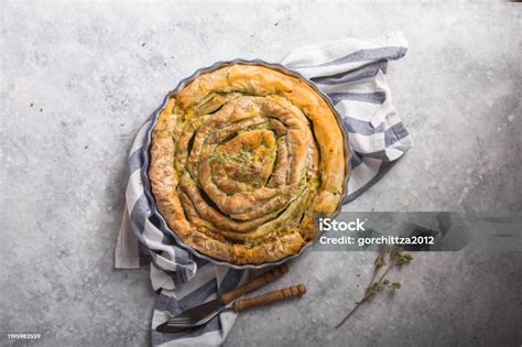 콘크리트 배경 위에 그리스 어 파이 스파나코 피타 필로 페이스트리에서 채식 또는 비건 시금치 파이에 대한 아이디어와 조리법은