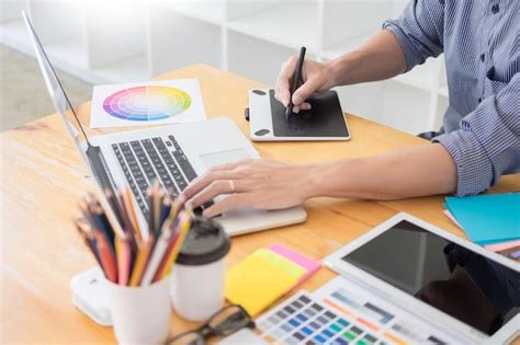 premium photo businessman using graphics tablet and laptop at desk in