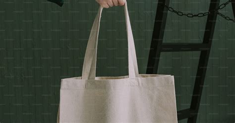 손에 가방을 들고 있는 사람 사진 Unsplash의 토트 백 이미지