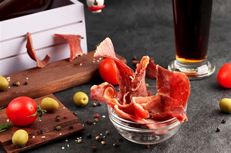 유기농 수제 식품 어두운 배경에 유리 컵에 향신료와 육포조각 조미료와 거친 소금 붉은 체리 토마토 올리브 맥주 에 대한 천연 간식 0명에 대한 스톡 사진 및 기타 이미지