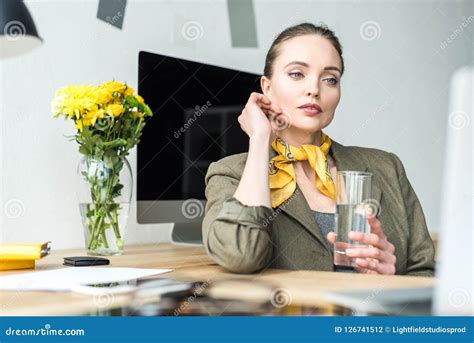 Beautiful Pensive Businesswoman Holding Glass Of Water And Looking Away
