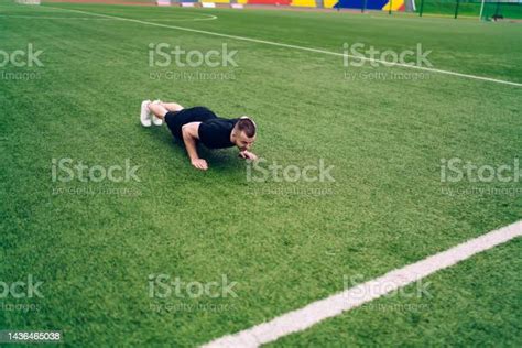 강한 백인 남성 운동 선수는 근육을 워밍업하기 위해 운동을하는 팔 굽혀 펴기를하고 경기장 훈련 몸과 체력에 운동하는 피트니스 목표에 도달하는 20 대 힙 스터 남자를