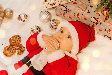 아름다운 어린 소년이 크리스마스를 축하한다 연말 연시 크리스마스 의상을 입은 아기 산타의 옷과 새해 나무 가까이 모피에 선물을 얹은 아기 12월에 대한 스톡 사진 및 기타