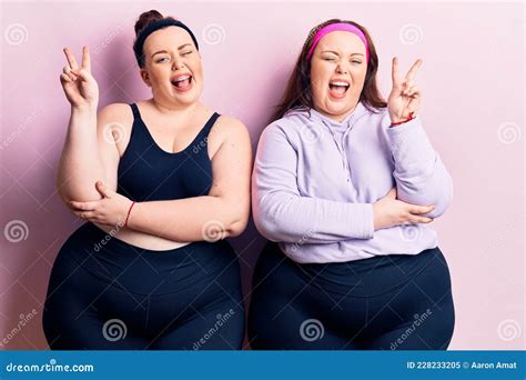 Young Plus Size Twins Wearing Sportswear Smiling With Happy Face Winking At The Camera Doing