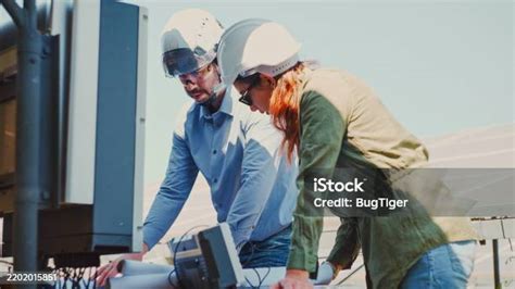 두 명의 서비스 엔지니어 또는 전기 기술자가 변압기 현장을 점검하고 친환경 에너지 태양광 발전소 운영 문제를 해결하기 위해 노력하고 있습니다 태양 에너지 발전소의 기술자