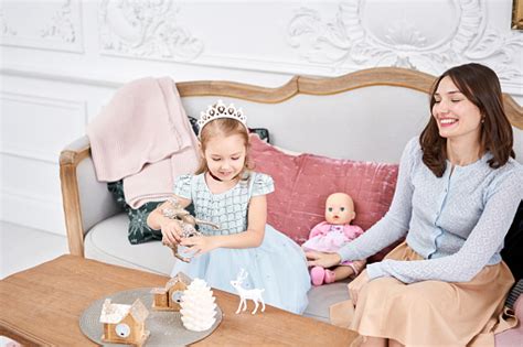 쾌활한 엄마는 그녀의 귀여운 아기 딸을 포용 부모와 어린 아이는 실내 크리스마스 트리 근처 재미를 사랑하는 가족 메리 크리스마스와 새해 복 과 새해 12월에 대한 스톡 사진