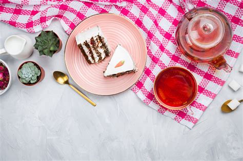 유리 주전자와 차 잔 스푼 채식 당근 케이크 조각 건조 장미 봉 오리와 슈가 큐브 차 시간 개념 Flatlay 시멘트 배경 0