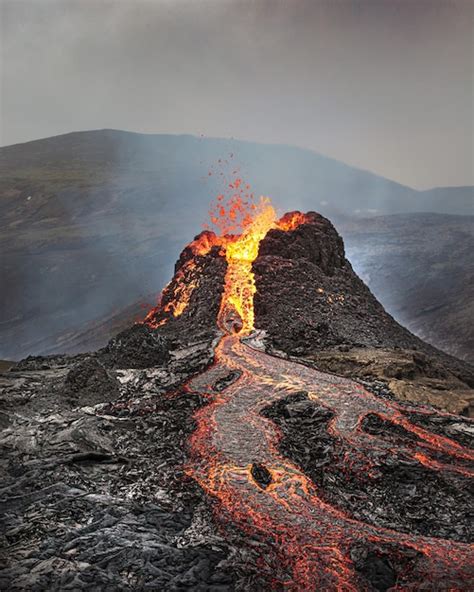 Premium Photo Beautiful Shot Of An Active Volcano With Flowing Lava And Smoke Under A Clear Sky