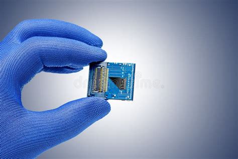 Hand Holds A Cpu Against The Grey Blue Background Concept Of