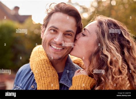 Portrait Of Happy Loving Couple With Woman Giving Man Kiss On The Cheek Stock Photo Alamy