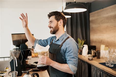 바리스타는 기성품 커피 필터를 들고 충성도가 높은 고객을 즐겁게 맞이합니다 35 39세에 대한 스톡 사진 및 기타 이미지