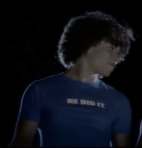 A Man With Curly Hair Wearing A Blue Shirt