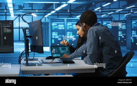 Multiethnic Coworkers Doing System Analysis Of Server Farm Supercomputers Using Tablet Diverse