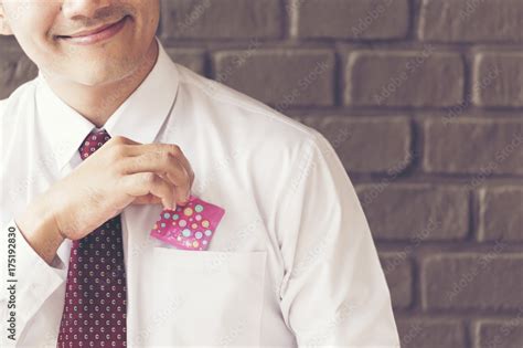 Sexy Man Smiling Holding Condom From His Pocket Safe Sex Concept Stock Photo Adobe Stock
