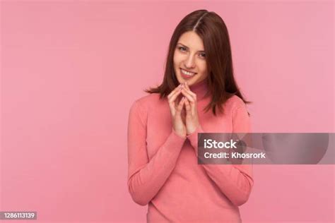 교활한 갈색 머리 여자 에 핑크 스웨터 몸짓 과 손가락 생각 사악한 트릭과 속임수 복수 계획을 통해 생각 25 29세에 대한