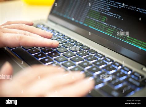 A Persons Hands Are Typing On A Laptop Displaying Hacker Code