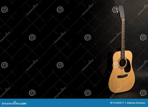Acoustic Guitar On A Black Background On The Right Side Of The Frame