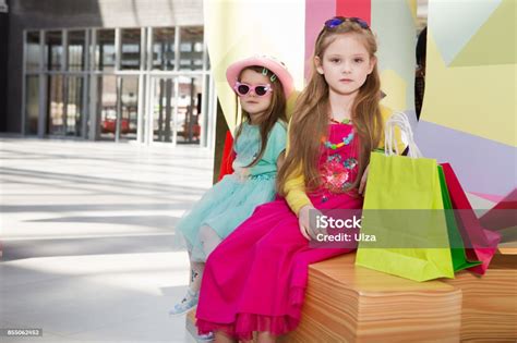 두 명의 밝은 작은 소녀 쇼핑백 함께 드레스와 선글라스 재미 쇼핑 몰 근처에 두 예쁜 여자 2명에 대한 스톡 사진 및 기타 이미지 Istock