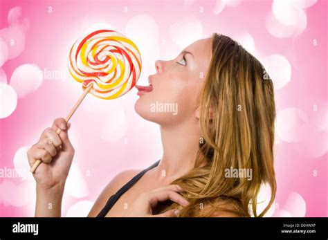 Woman Licking Sweet Sugar Candy Closeup With Pink Lights In The Background Stock Photo Alamy