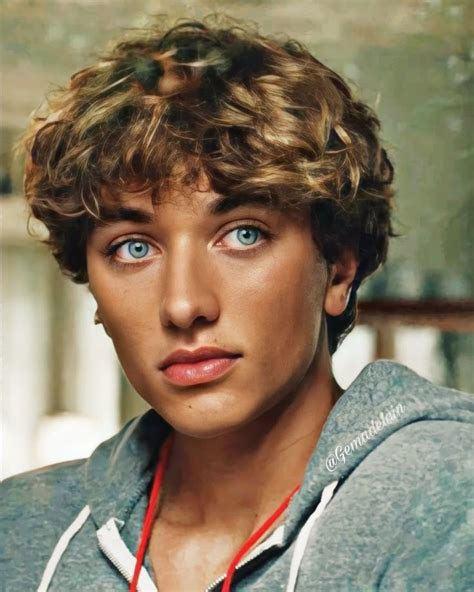 A Close Up Of A Person Wearing A Hoodie And Looking At The Camera With Blue Eyes