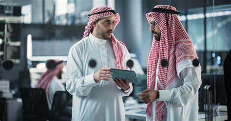 두 명의 다민족 아랍 동료가 소프트웨어 개발 프로젝트를 진행하는 동안 대화를 나누고 있습니다 사무실에서 태블릿 컴퓨터를 사용하여