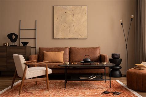 모형 포스터 프레임 갈색 소파 부클 안락의자 둥근 푸프 나무 찬장 슬리퍼 및 개인 액세서리가 있는 거실 인테리어의 세련된 구성 가정 장식 템플렛 0명에 대한 스톡 사진 및