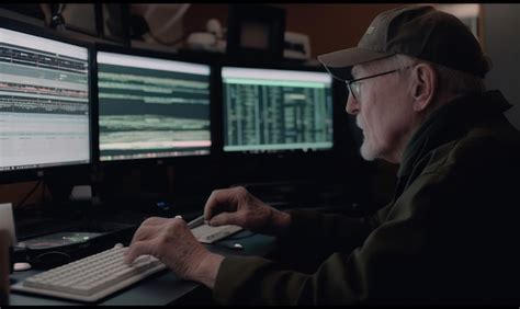 Premium Ai Image A Man Sits At A Desk In Front Of Two Computer Screens That Saycode