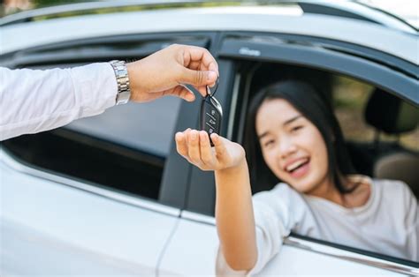 Une Femme Est Assise Dans Une Voiture Et Tend La Main Pour Recevoir Les